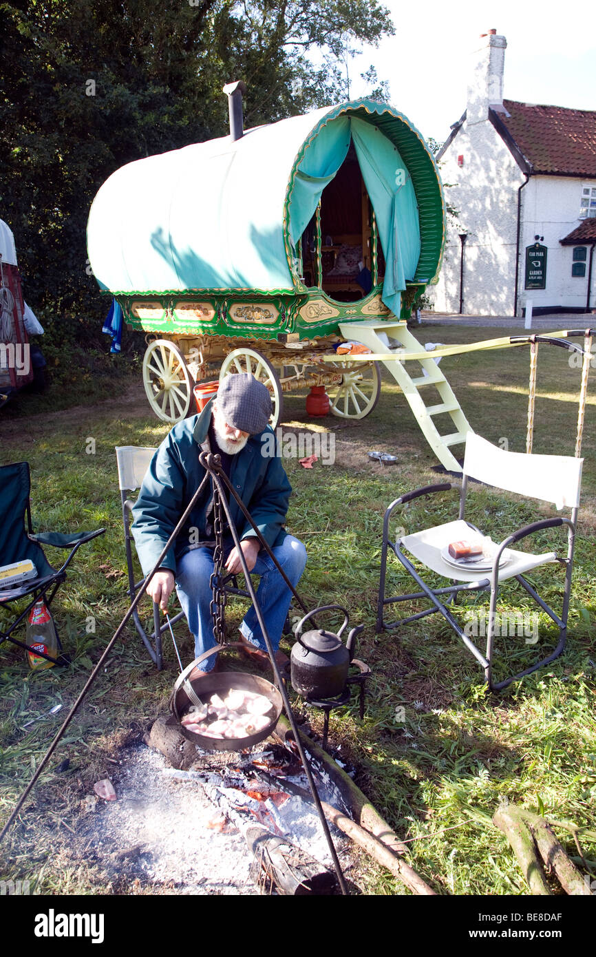 Man cooking his breakfast on open fire by his gypsy caravan, Saxtead ...