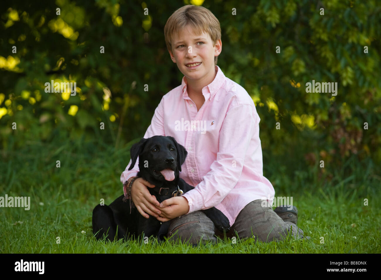Boy, 10, with a labrador puppy Stock Photo - Alamy