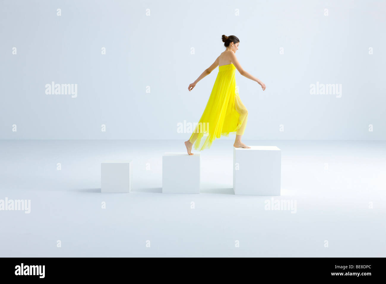 Woman stepping on progressively larger blocks Stock Photo - Alamy