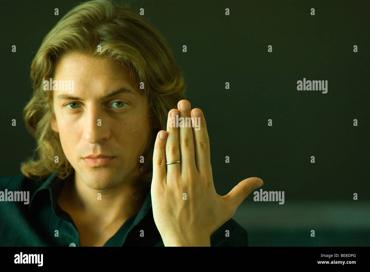Man holding up hand showing wedding ring Stock Photo - Alamy