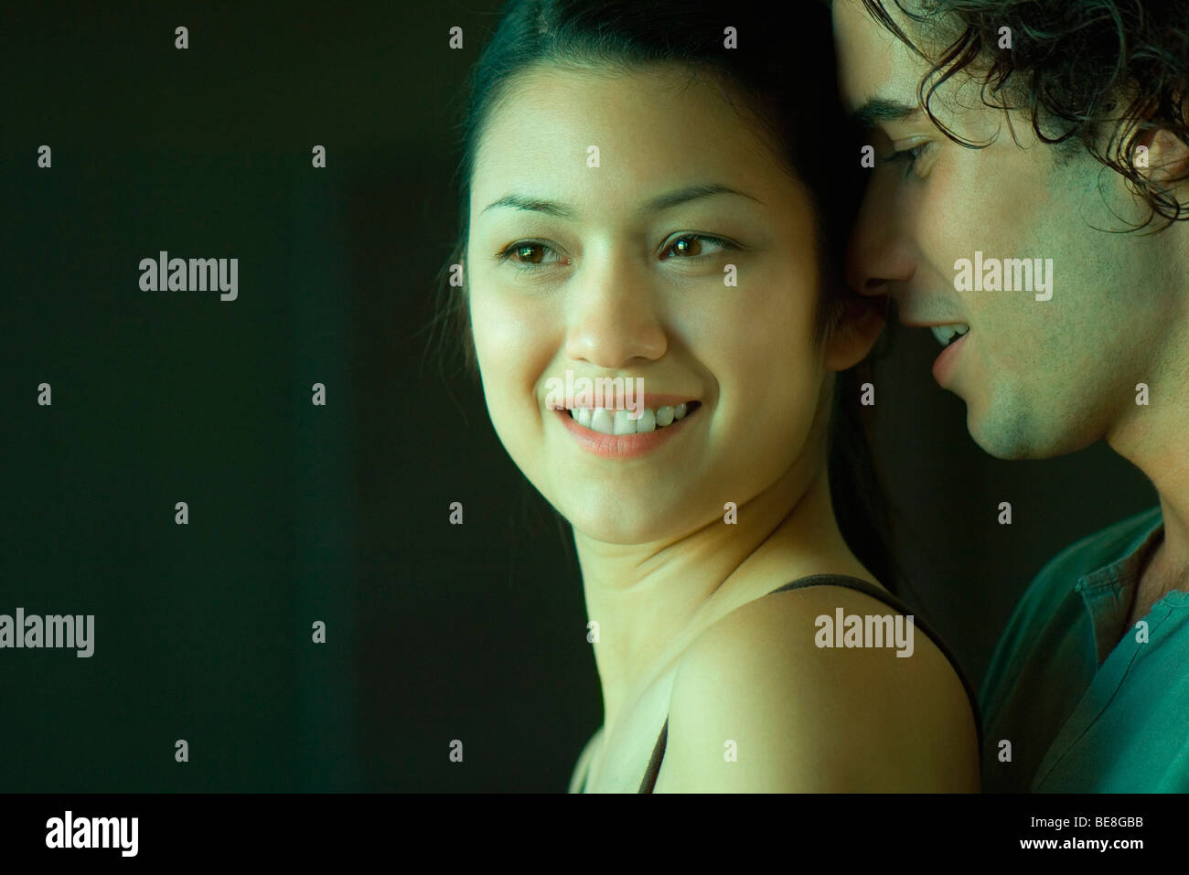 Young couple, man whispering in woman's ear Stock Photo - Alamy