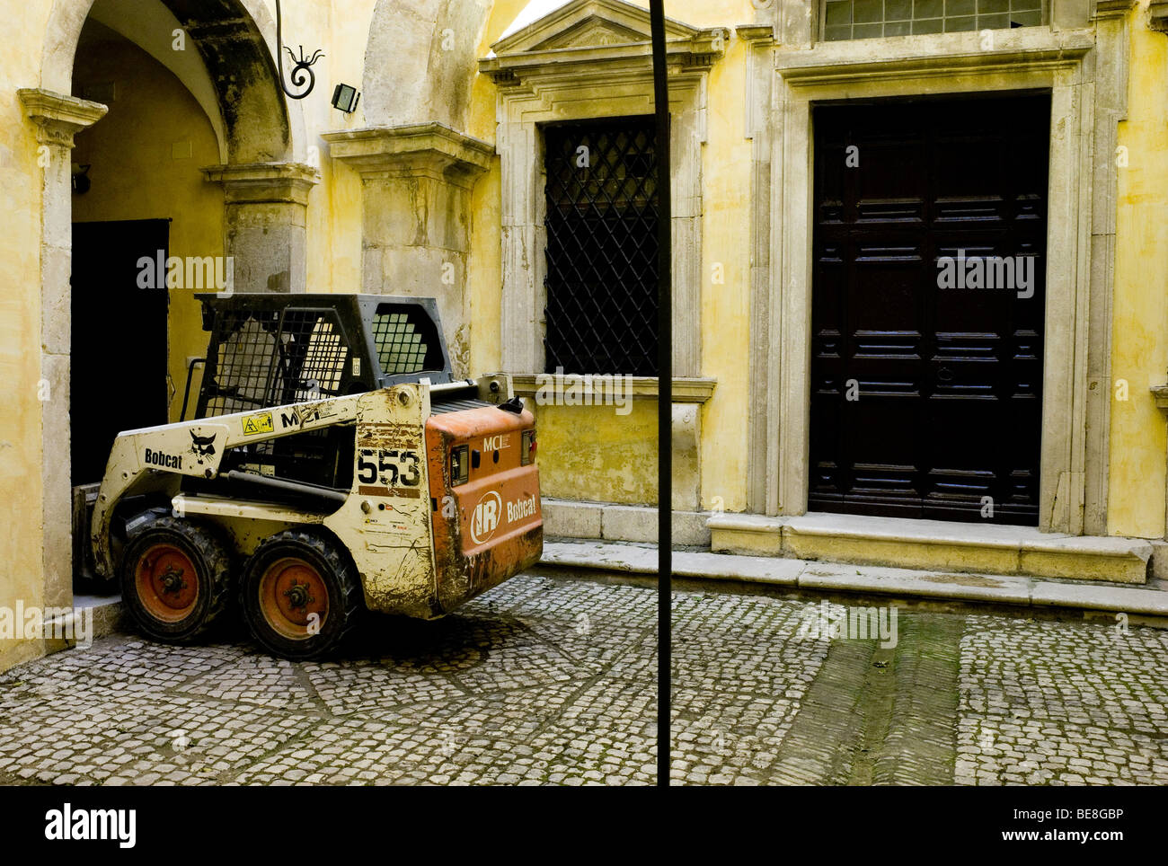 Formia, Italy. A small earth moving construction vehicle parked inside ...