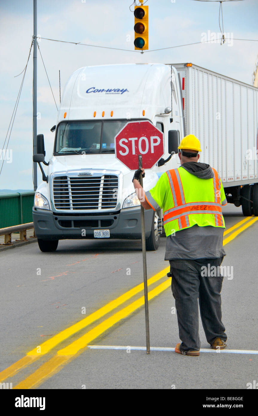 Construction Worker Controls traffic on International Bridge Stock ...