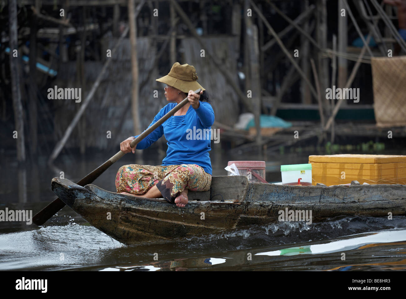 Cambodia boat people. A woman navigating the waterways of the Tonle Sap ...