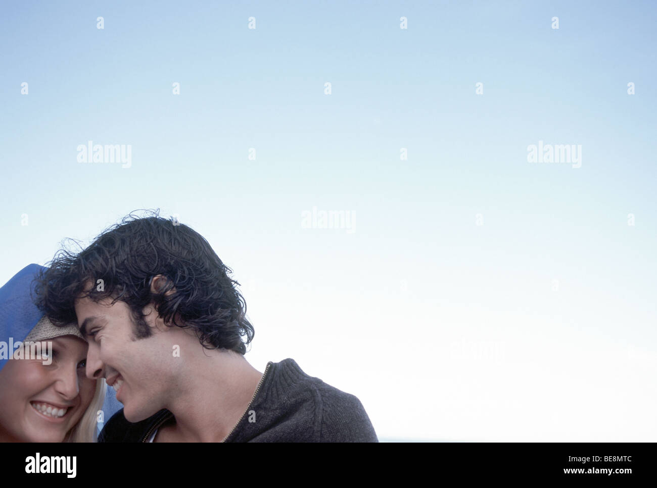Teenage couple with heads together smiling Stock Photo - Alamy