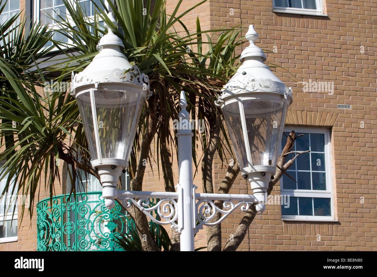 A pair of ornate street lights in front of a wrought iron balcony Stock ...