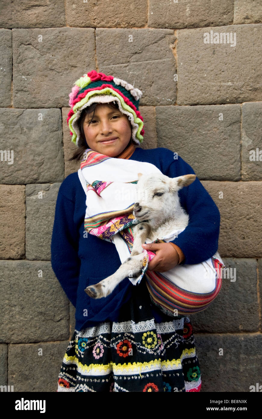 Peru, Cuzco, UNESCO World Heritage Site, young girl holding baby lamb ...