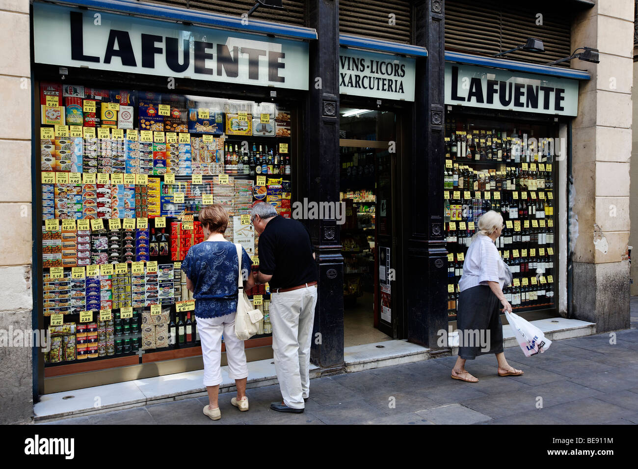 People window shopping at a traditional corner shop in Barri Gotic ...