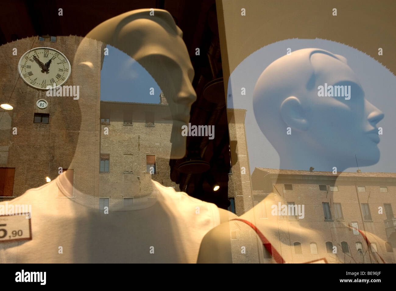 display window of a boutique reflecting the castle Castello Estense of ...