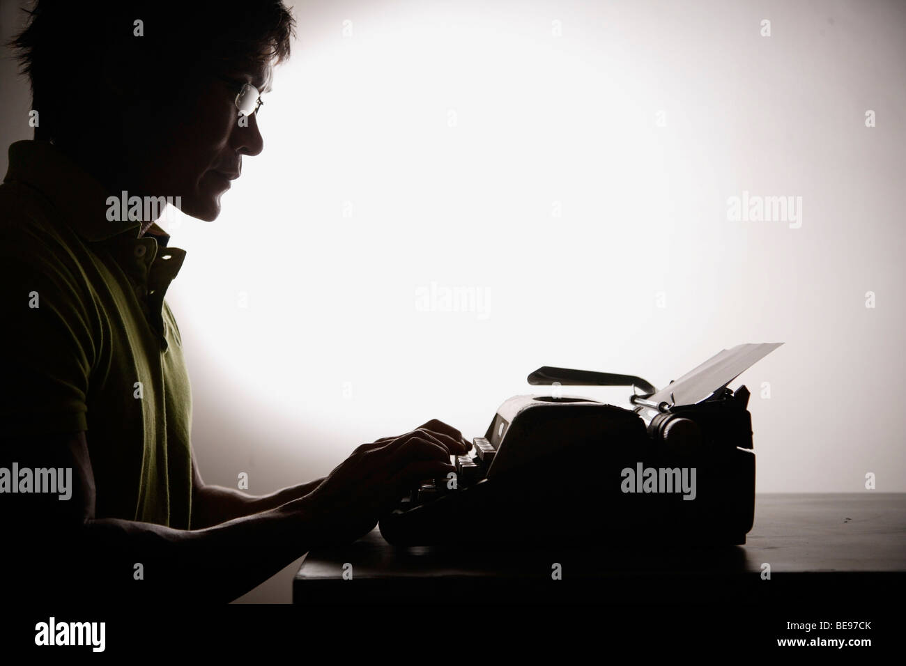 Profile of man at type writer Stock Photo - Alamy
