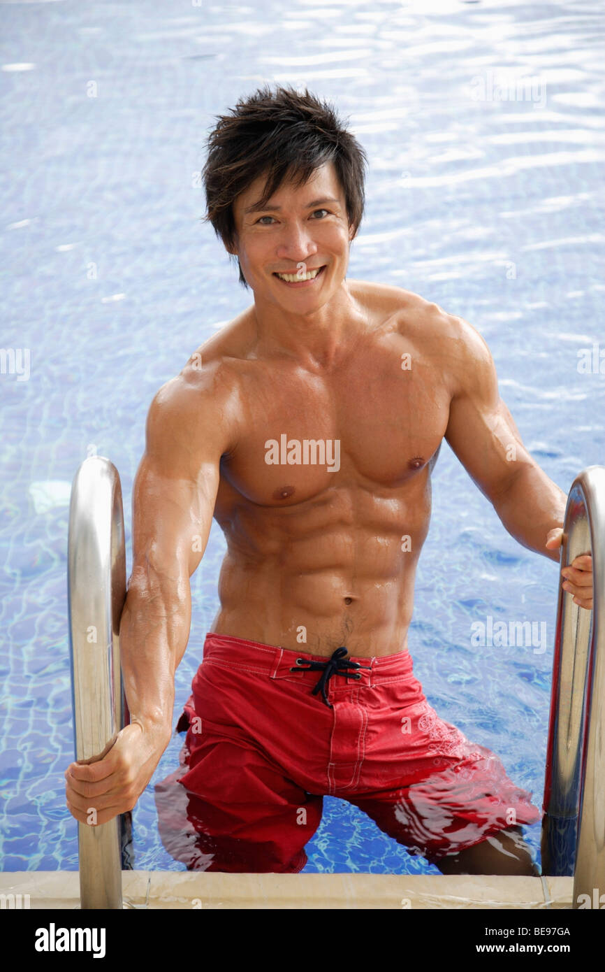 Portrait of man climbing out of pool Stock Photo - Alamy