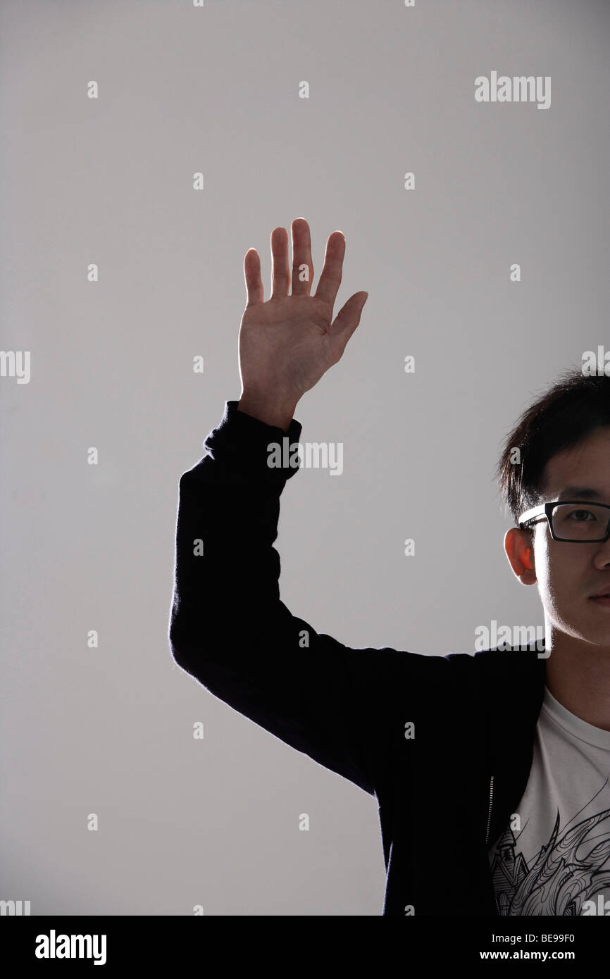 young man raising his hand Stock Photo - Alamy
