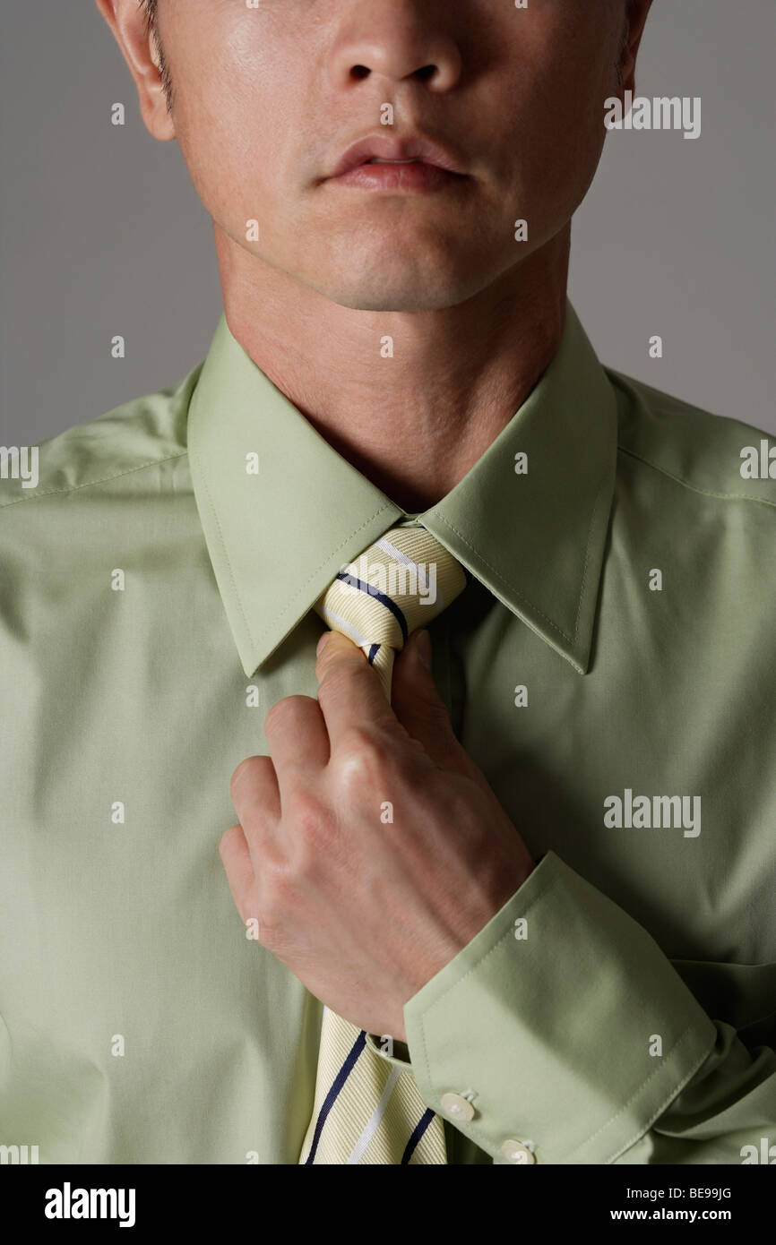 crop portrait of man tightening tie Stock Photo - Alamy