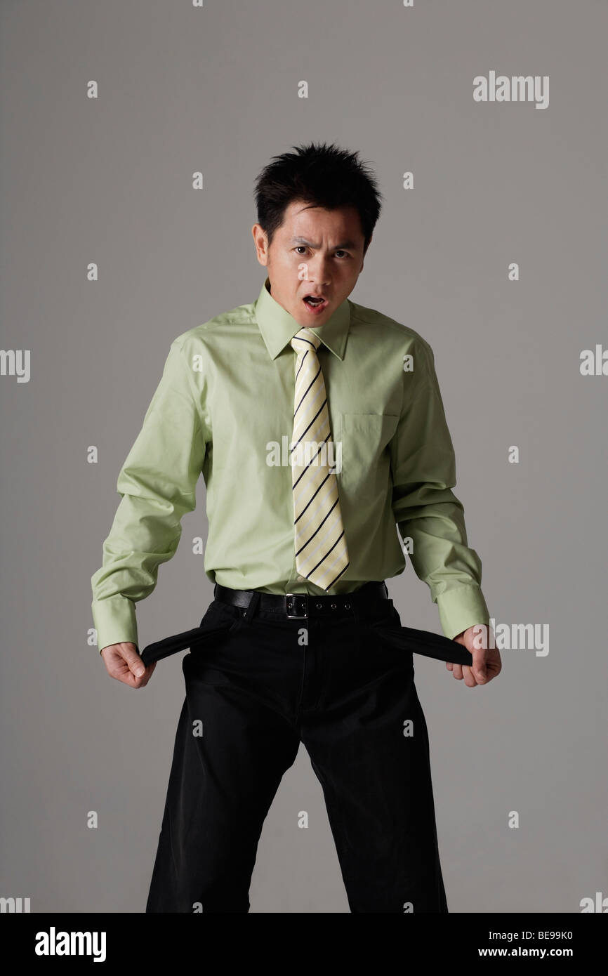 man looking at pockets with empty pockets Stock Photo - Alamy