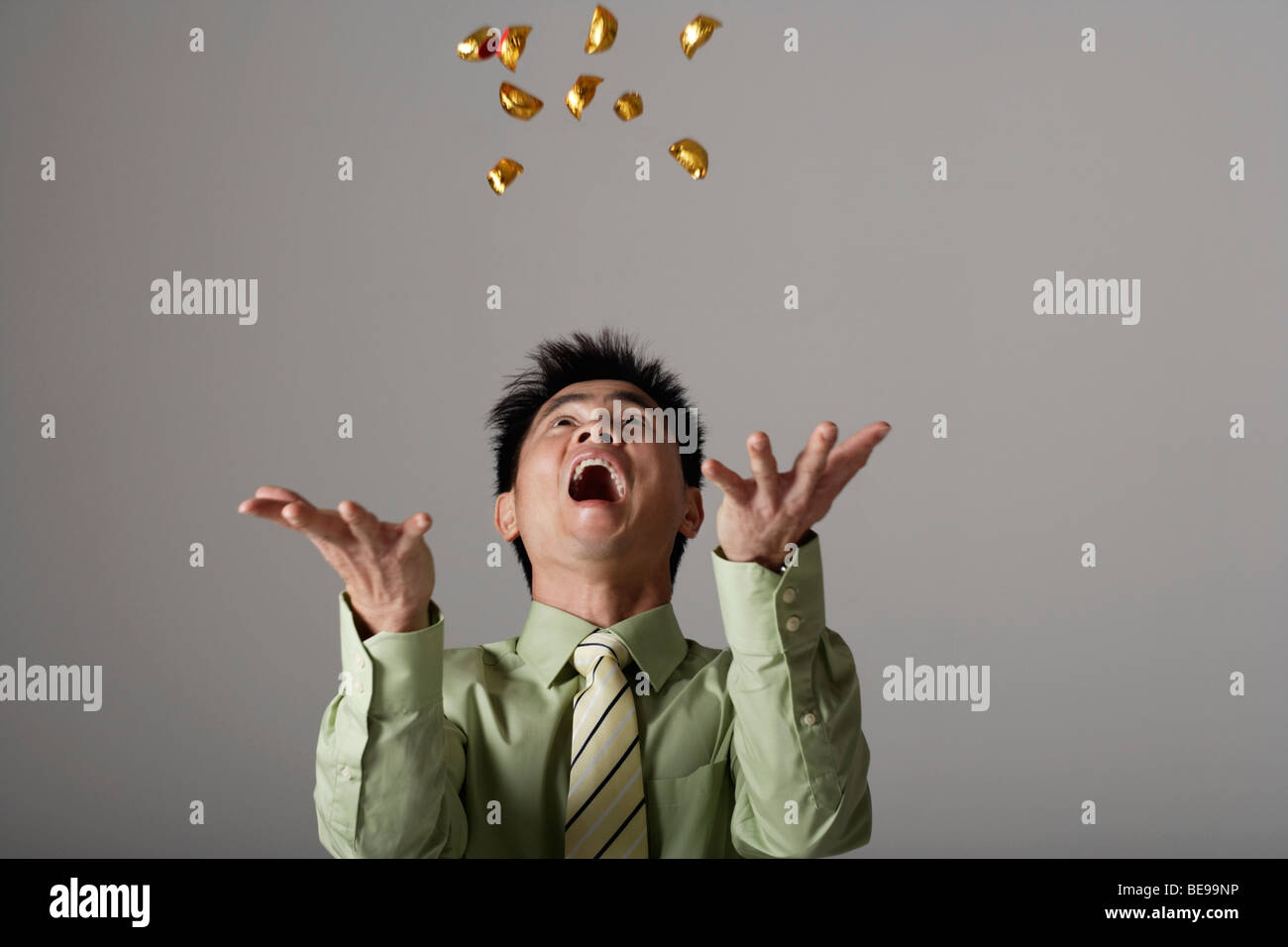 man throwing gold into the air Stock Photo - Alamy