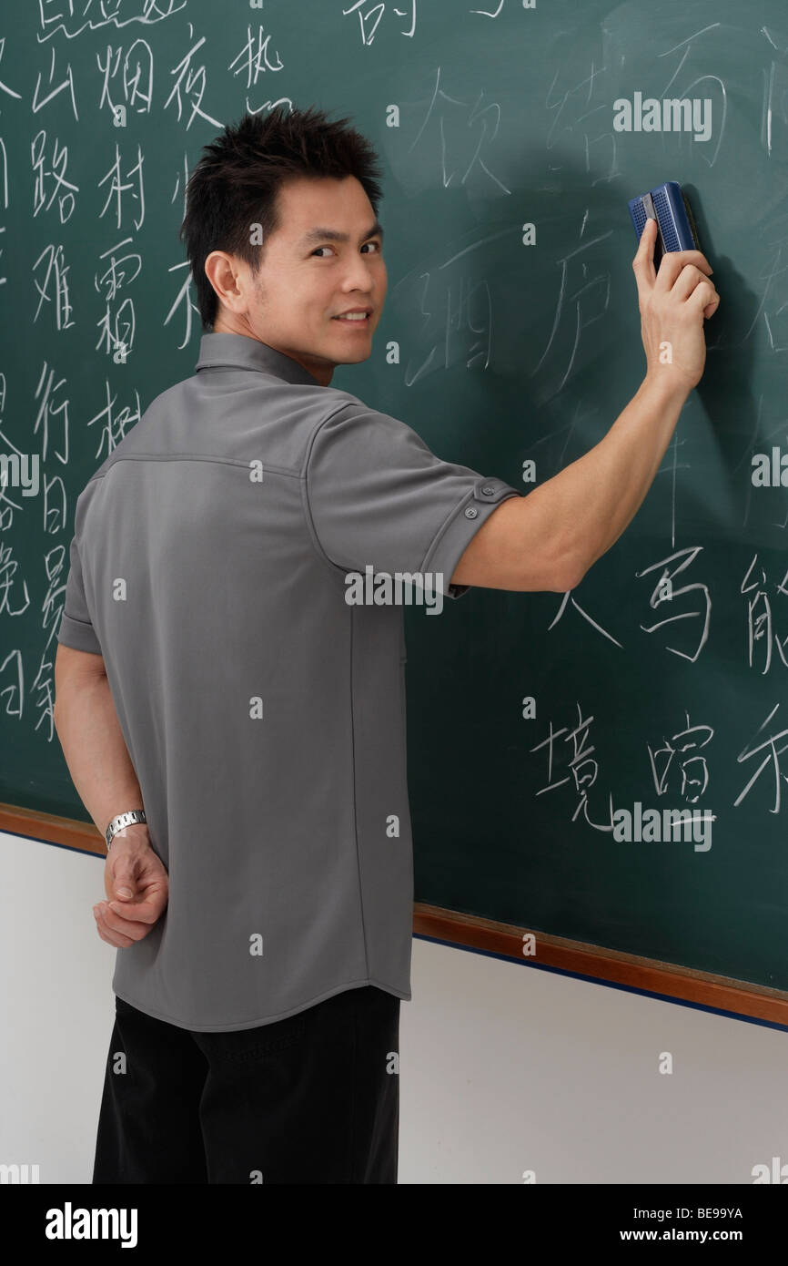man erasing Chinese characters on chalk board Stock Photo - Alamy