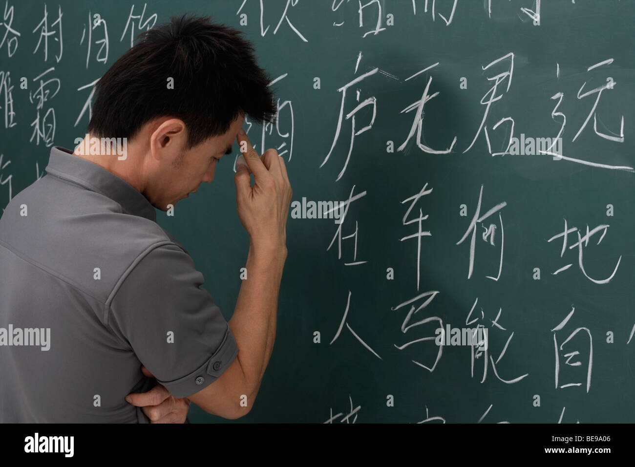 man thinking in front of Chinese characters on chalk board Stock Photo ...