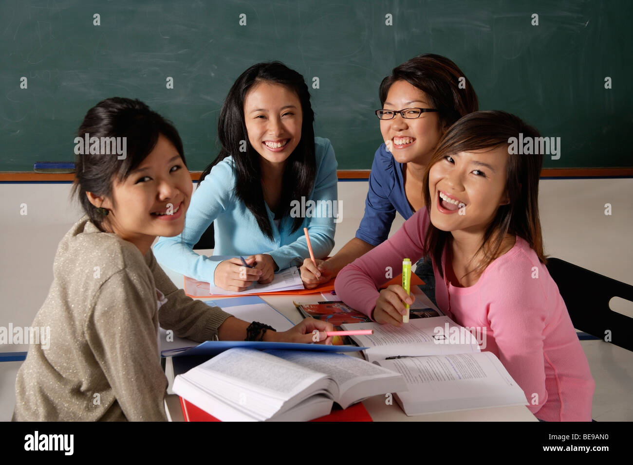 Four young women studying together and laughing Stock Photo - Alamy