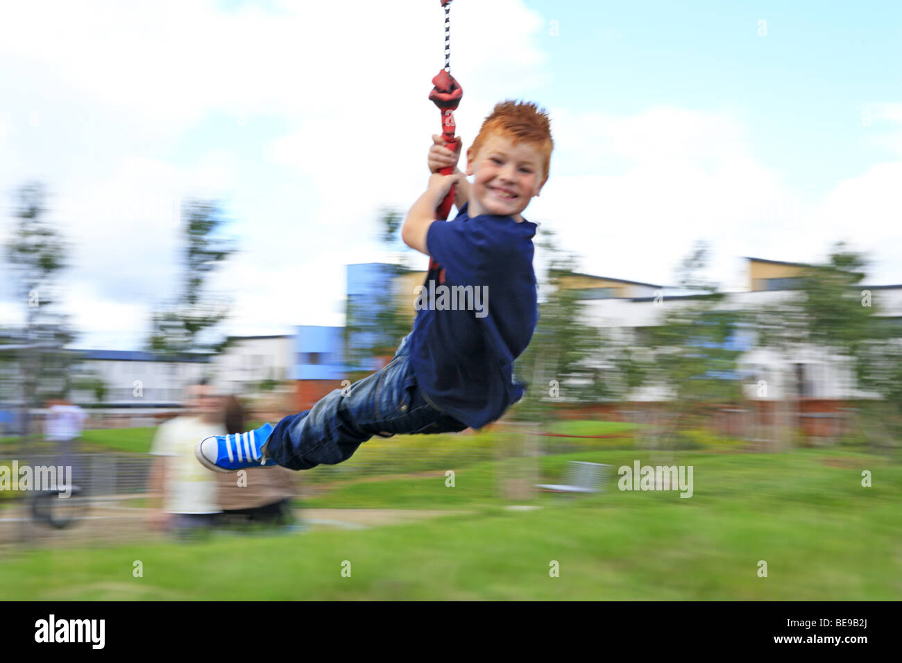 young boy on a zip line at a playground Stock Photo - Alamy