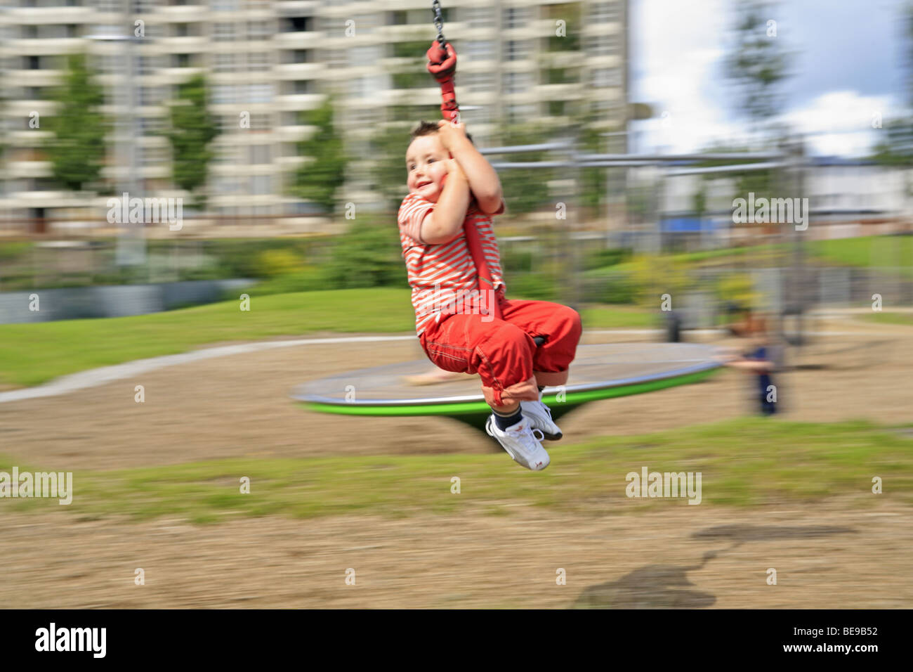 young boy on a zip line at a playground Stock Photo - Alamy
