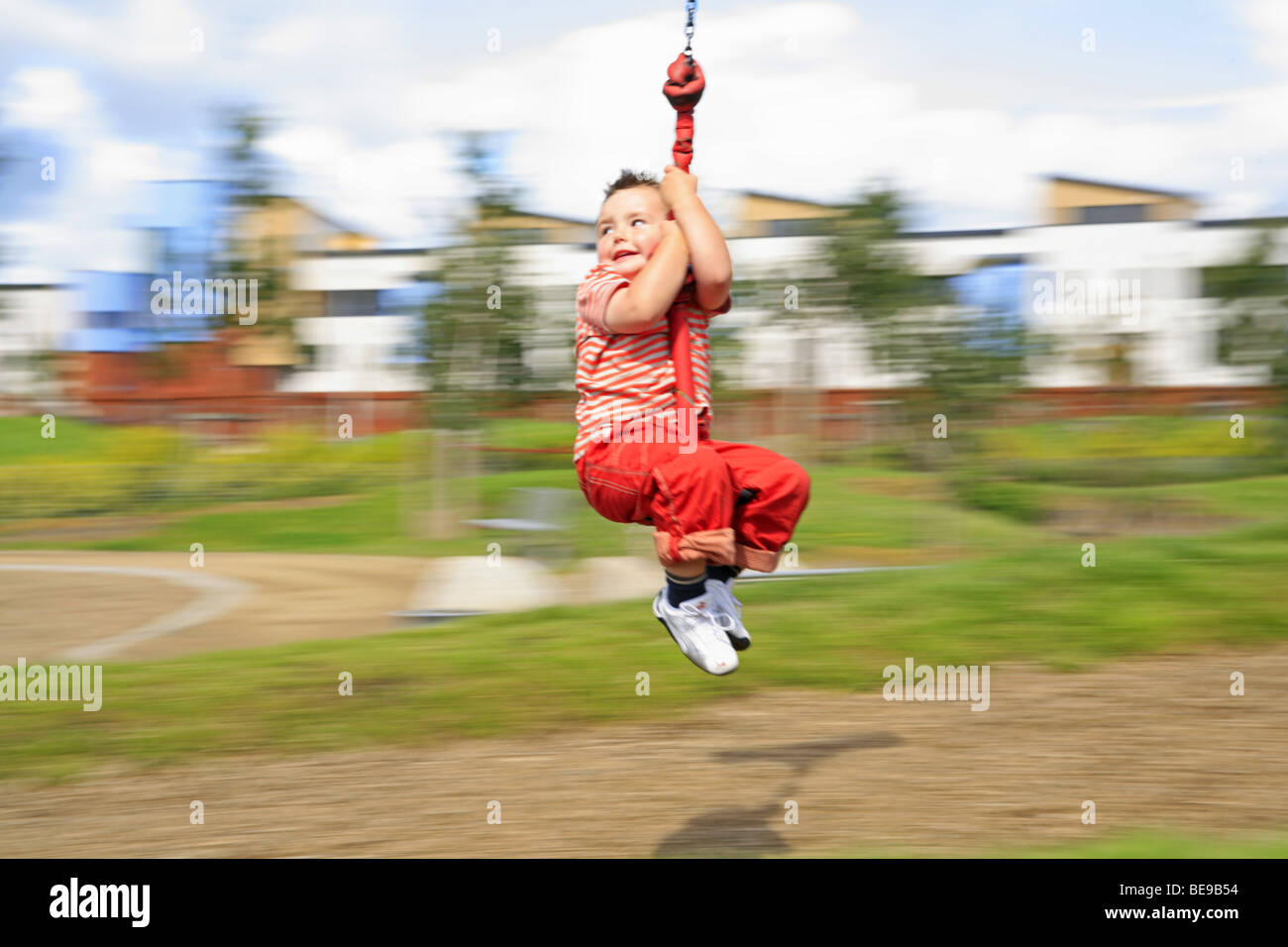 young boy on a zip line at a playground Stock Photo - Alamy