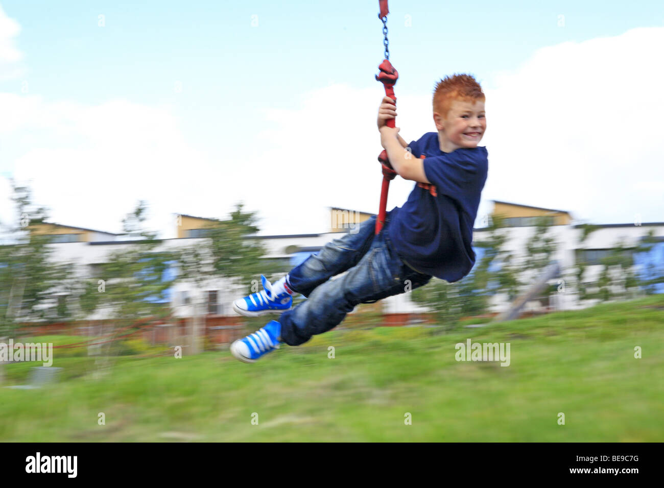 young boy on a zip line at a playground Stock Photo - Alamy