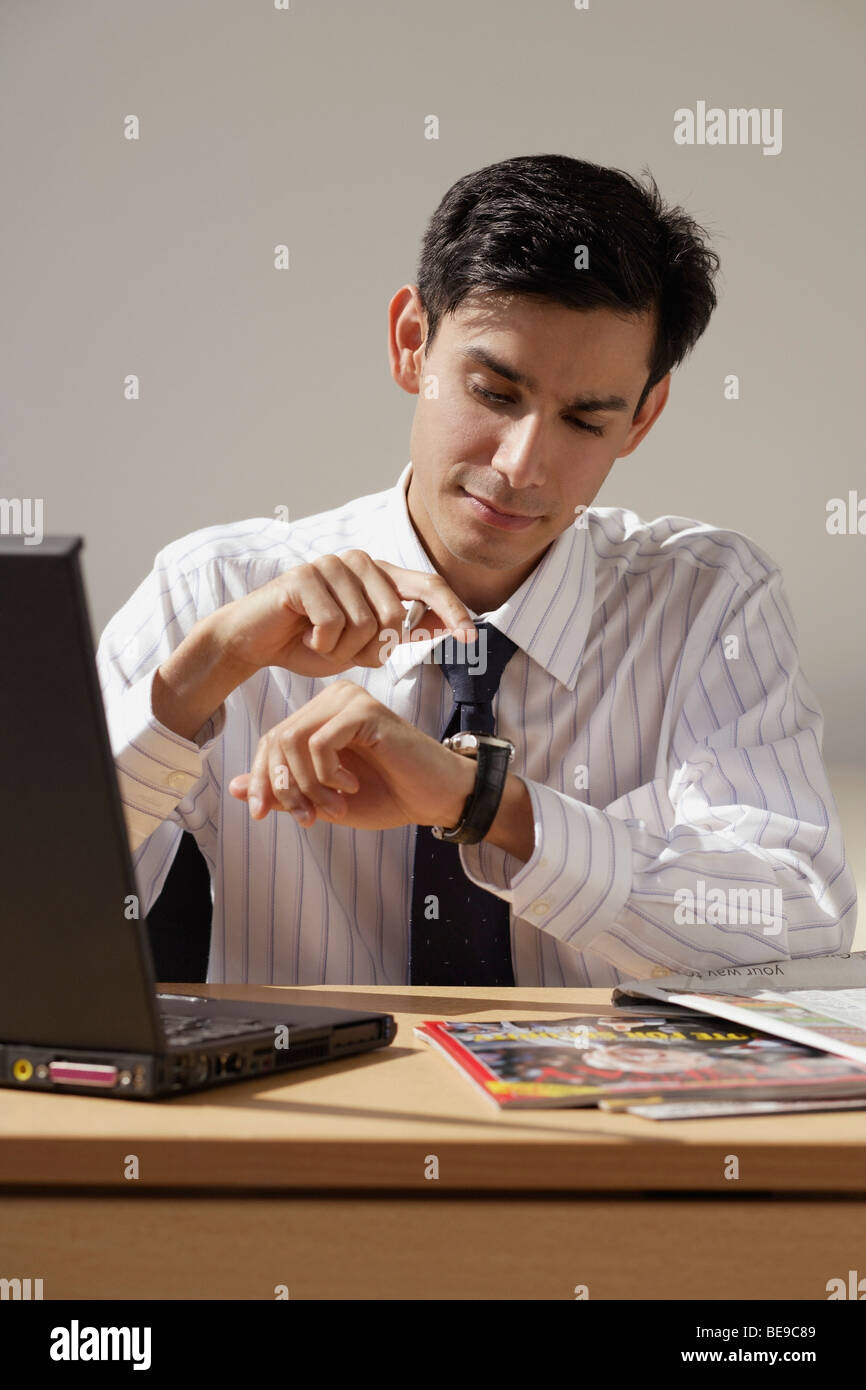 A man looks at his watch to check the time Stock Photo - Alamy