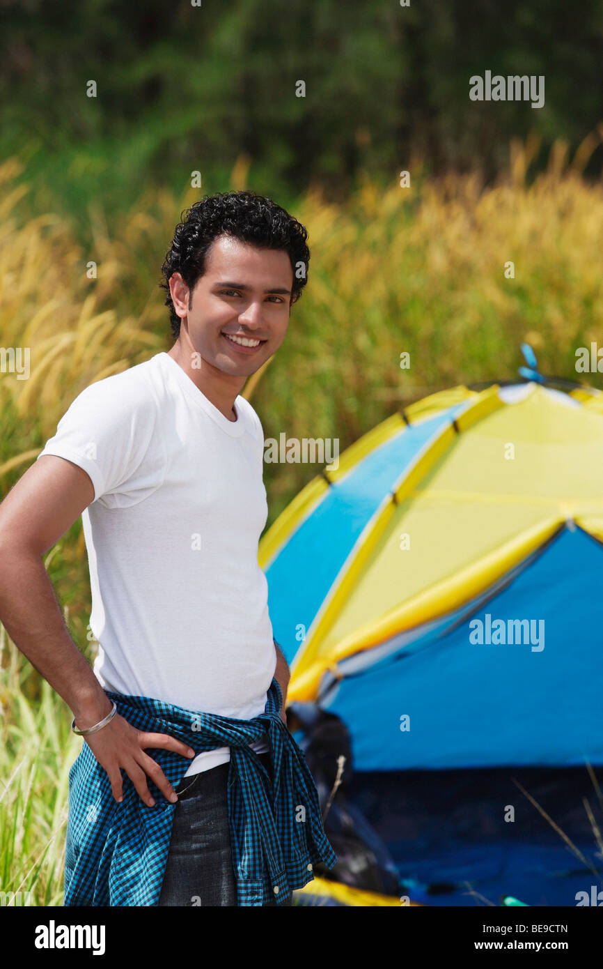 Young man camping smiling at camera Stock Photo - Alamy