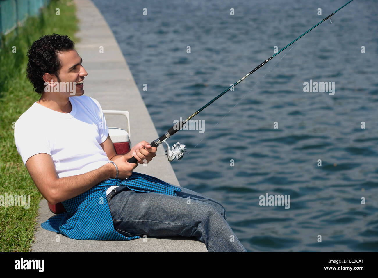 Young man fishing in river Stock Photo - Alamy