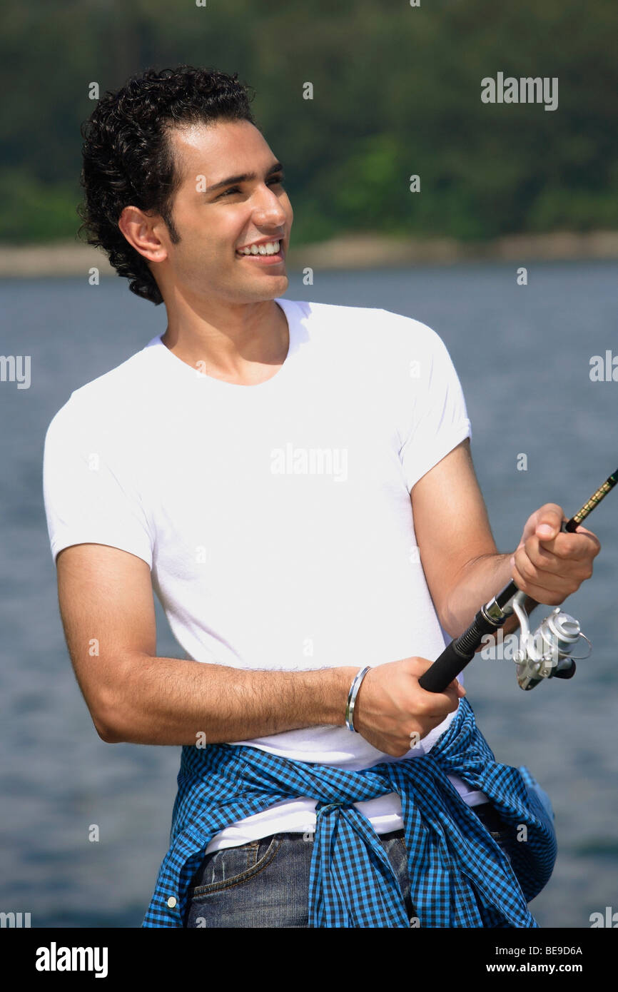 Young man fishing in river Stock Photo - Alamy