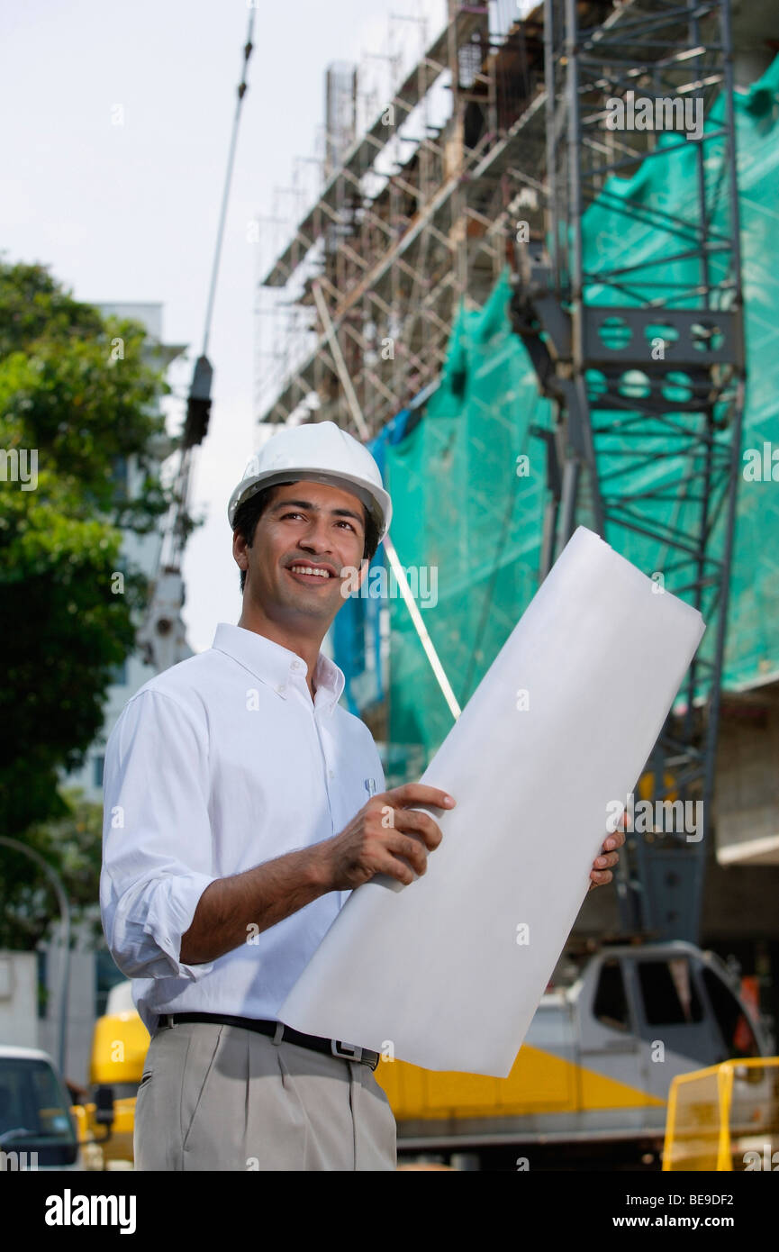 Man with plans, smiling into distance Stock Photo - Alamy