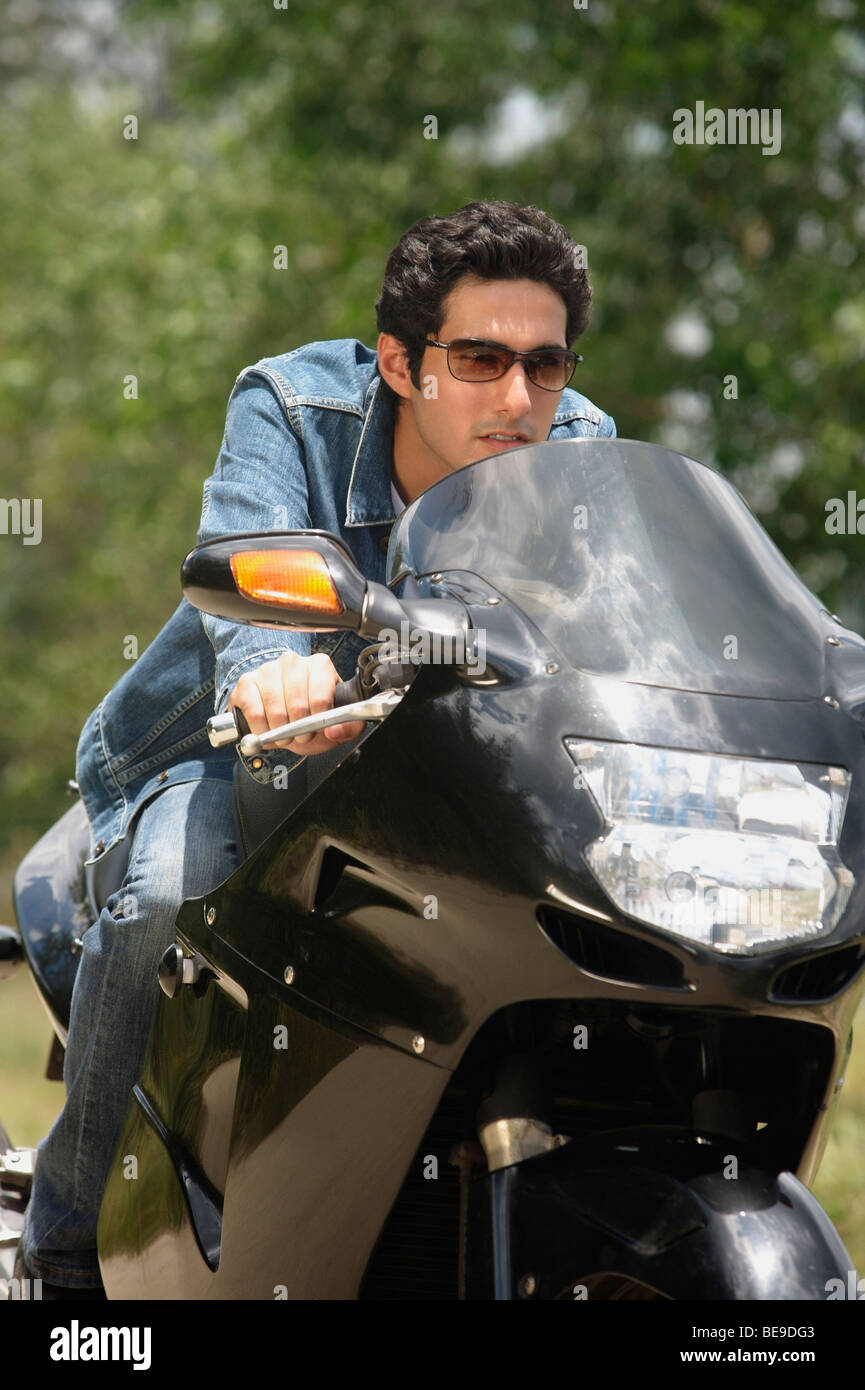 Young man riding motorbike Stock Photo - Alamy