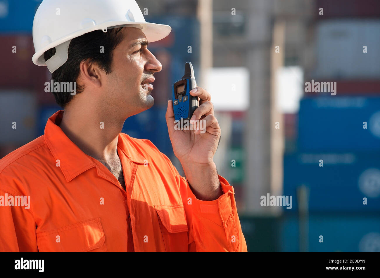 Man in work uniform using walkie talkie Stock Photo - Alamy