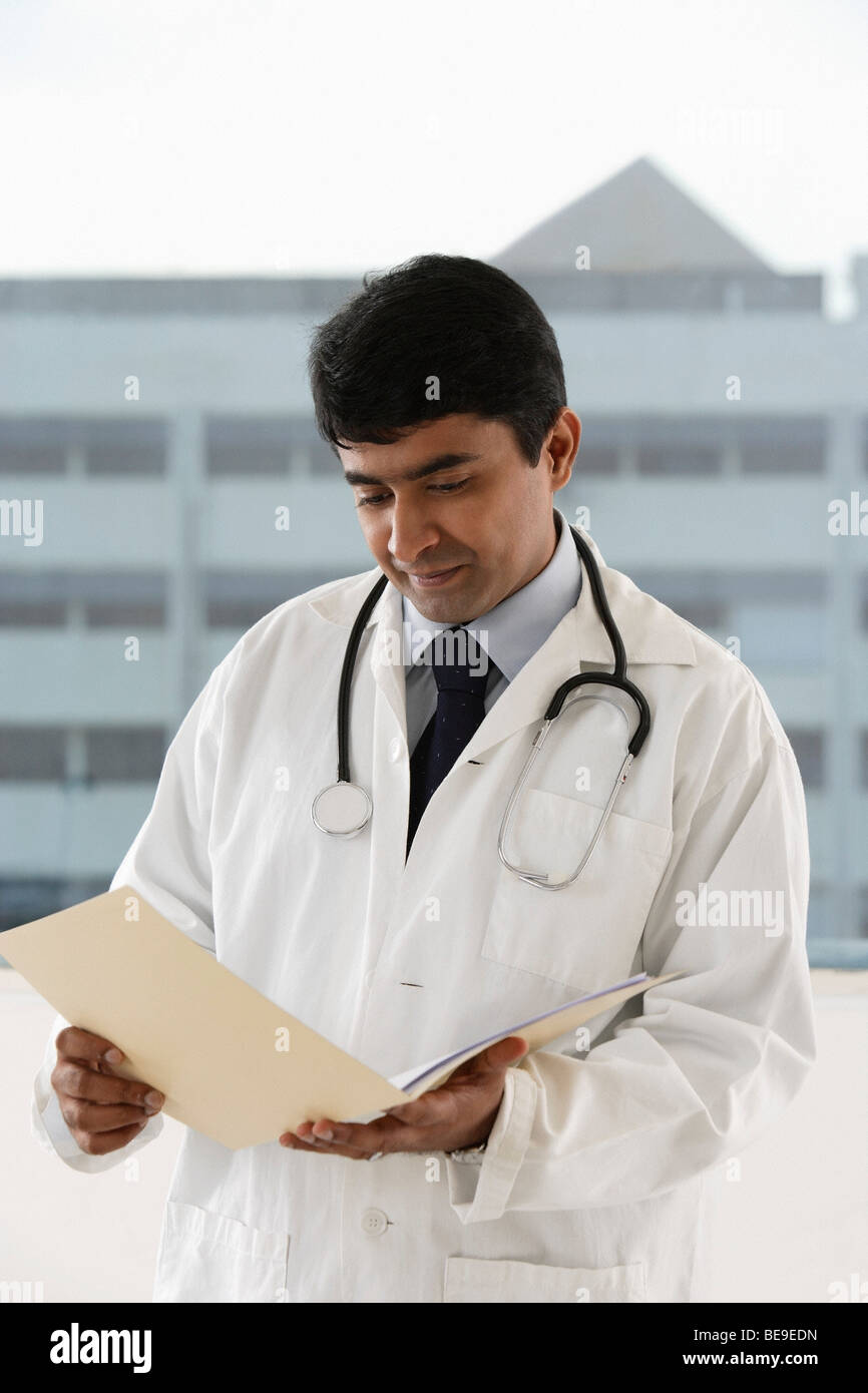 doctor looking at patient file Stock Photo - Alamy
