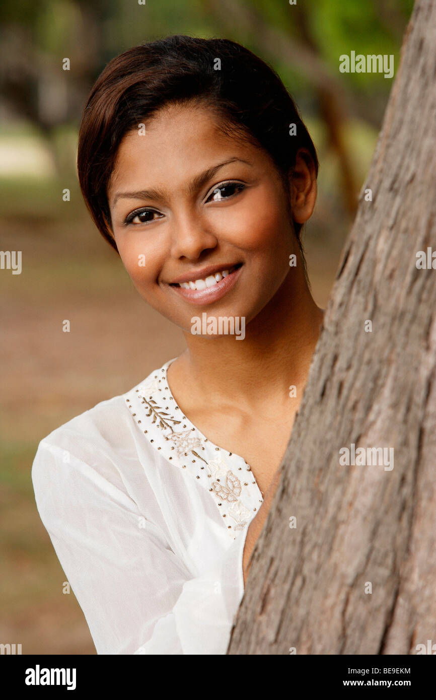 Woman standing behind a tree hi-res stock photography and images - Alamy