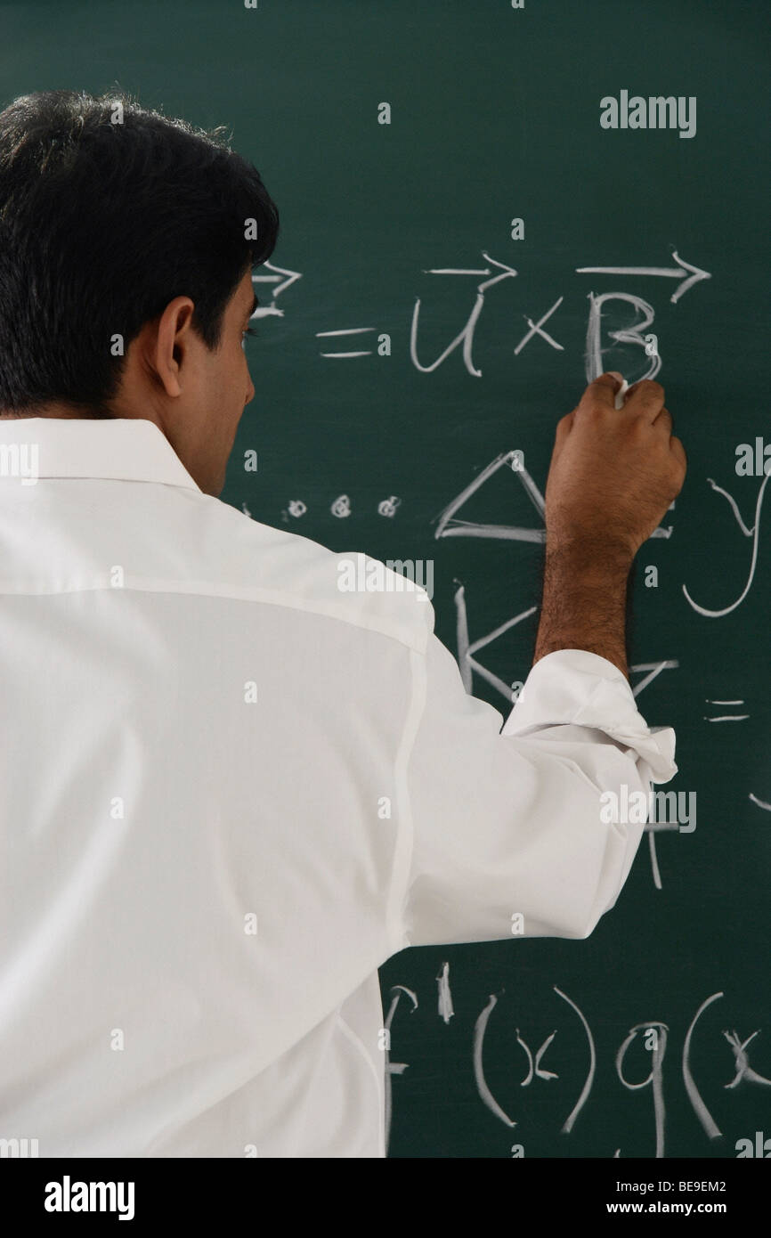 teacher writing formulas on chalkboard Stock Photo - Alamy