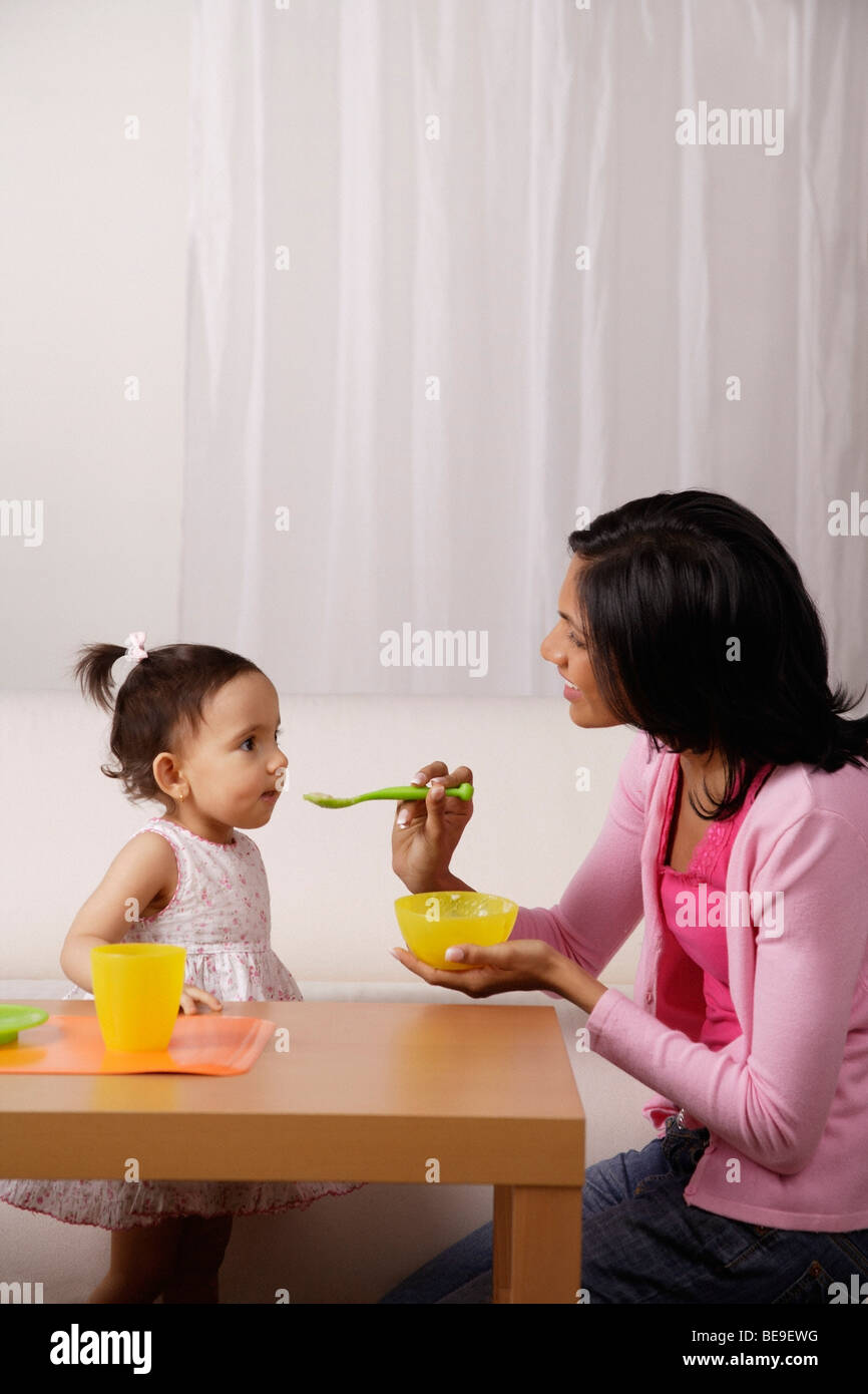 woman feeding food to her baby Stock Photo - Alamy