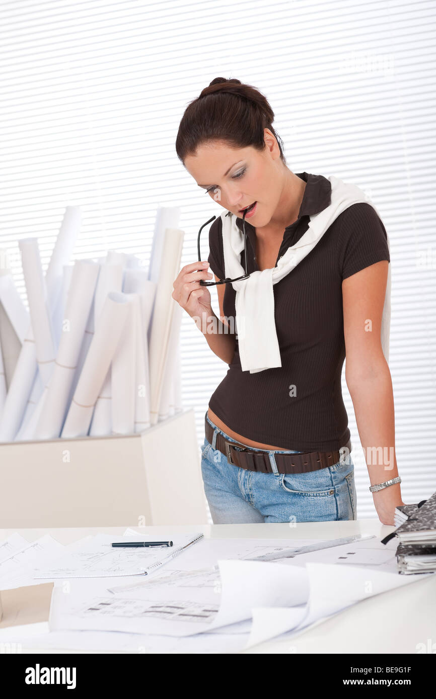 Successful architect woman with plans at the office Stock Photo - Alamy