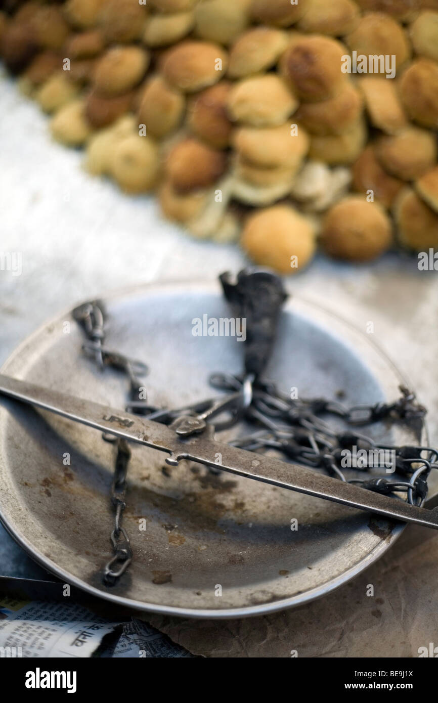 A set of scales and small cakes on sale on a food stall in Old Delhi ...