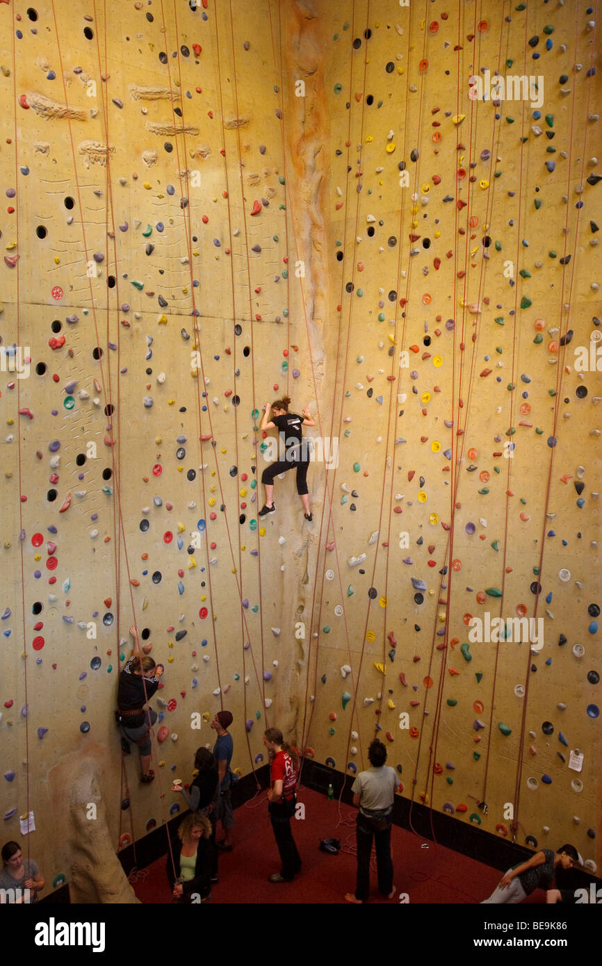 Mesije klimt met behulp van touw tegen een klimwand. Girl climbing ...