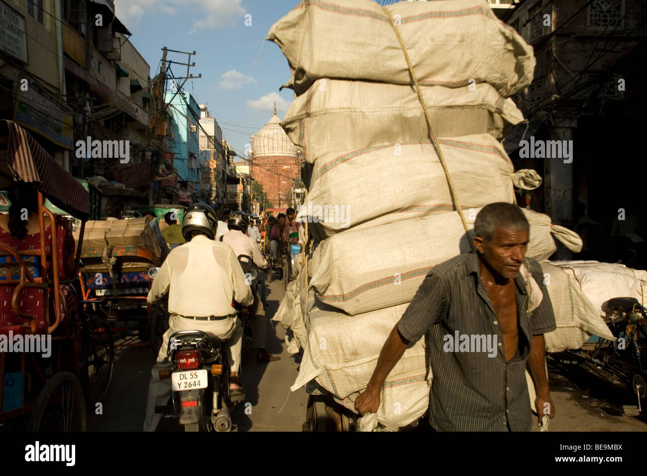 A man struggles through the congested streets of Old Delhi pulling a ...