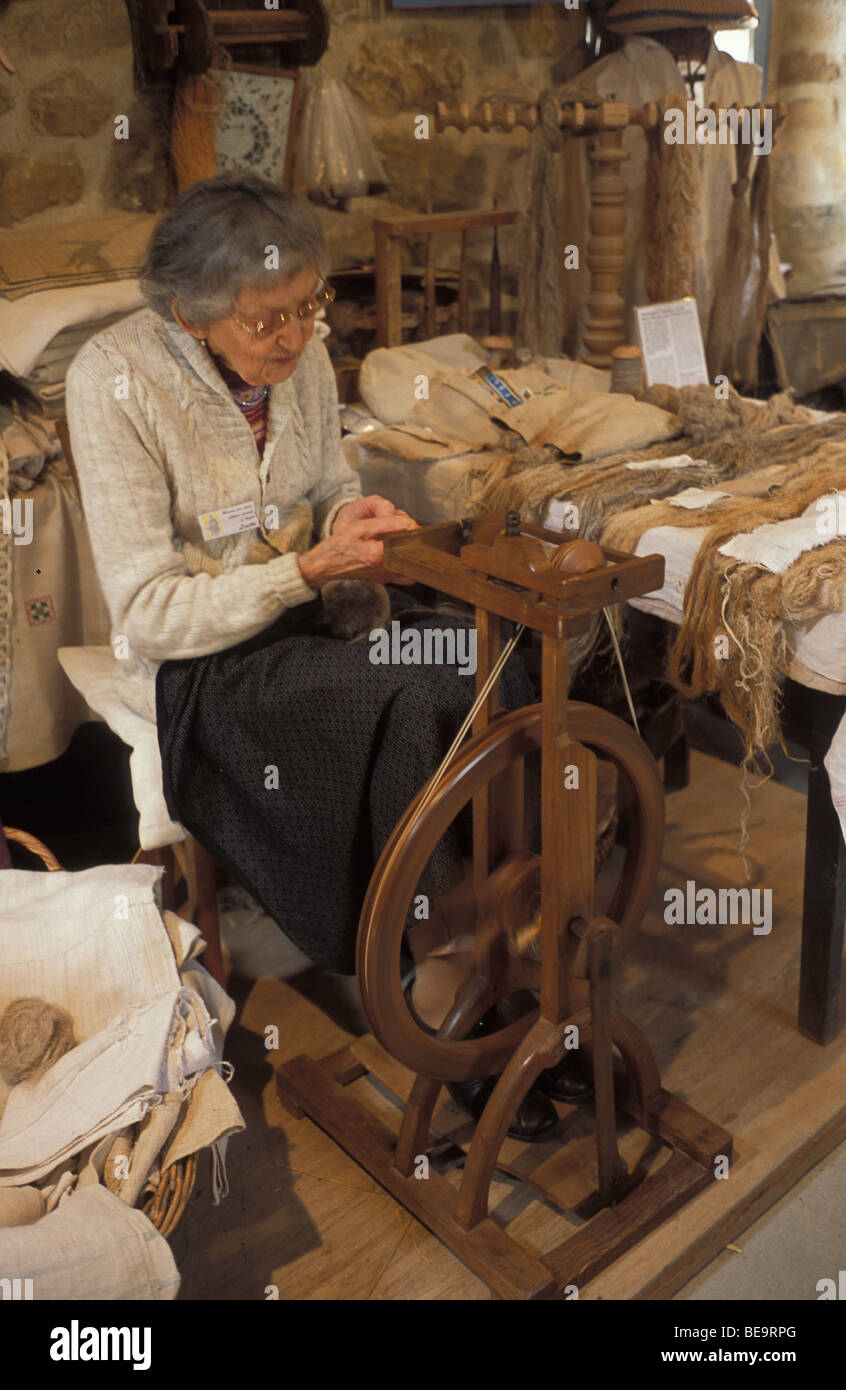 An old lady spining at the craft museum in Argol in Finistere Brittany ...