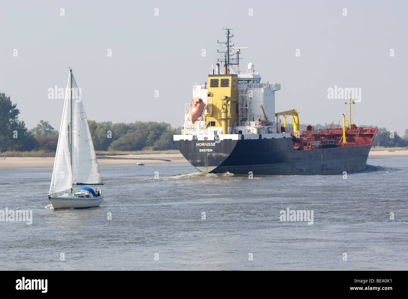 Tankship Hornisse and sailing boat on river Weser near Bremen, Germany ...