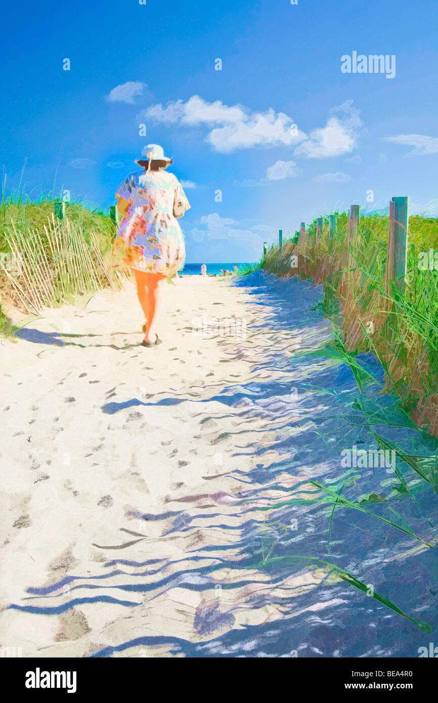 A woman walking along a sandy beach path Stock Photo - Alamy
