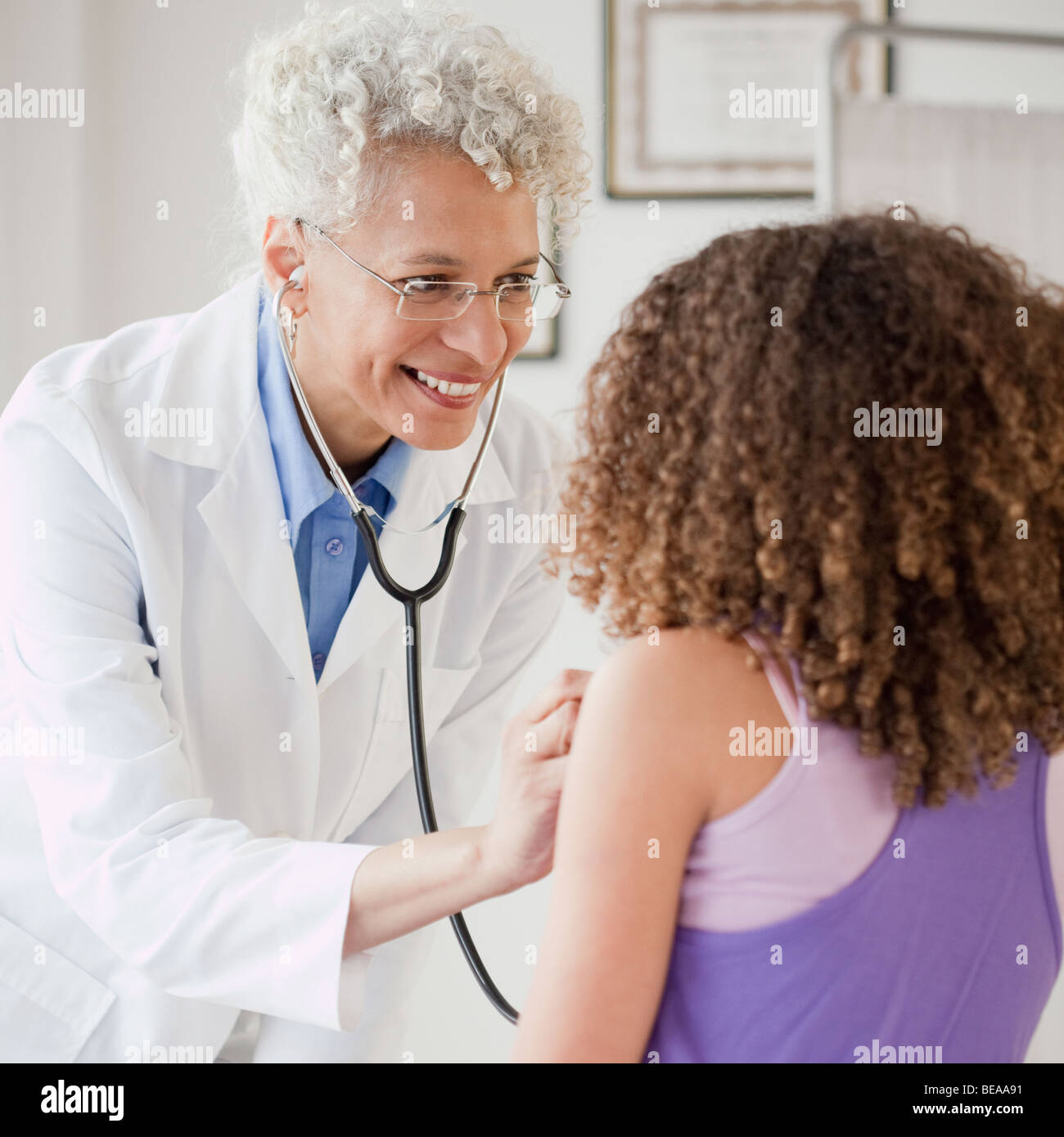 Doctor checking girl's heart with stethoscope Stock Photo - Alamy