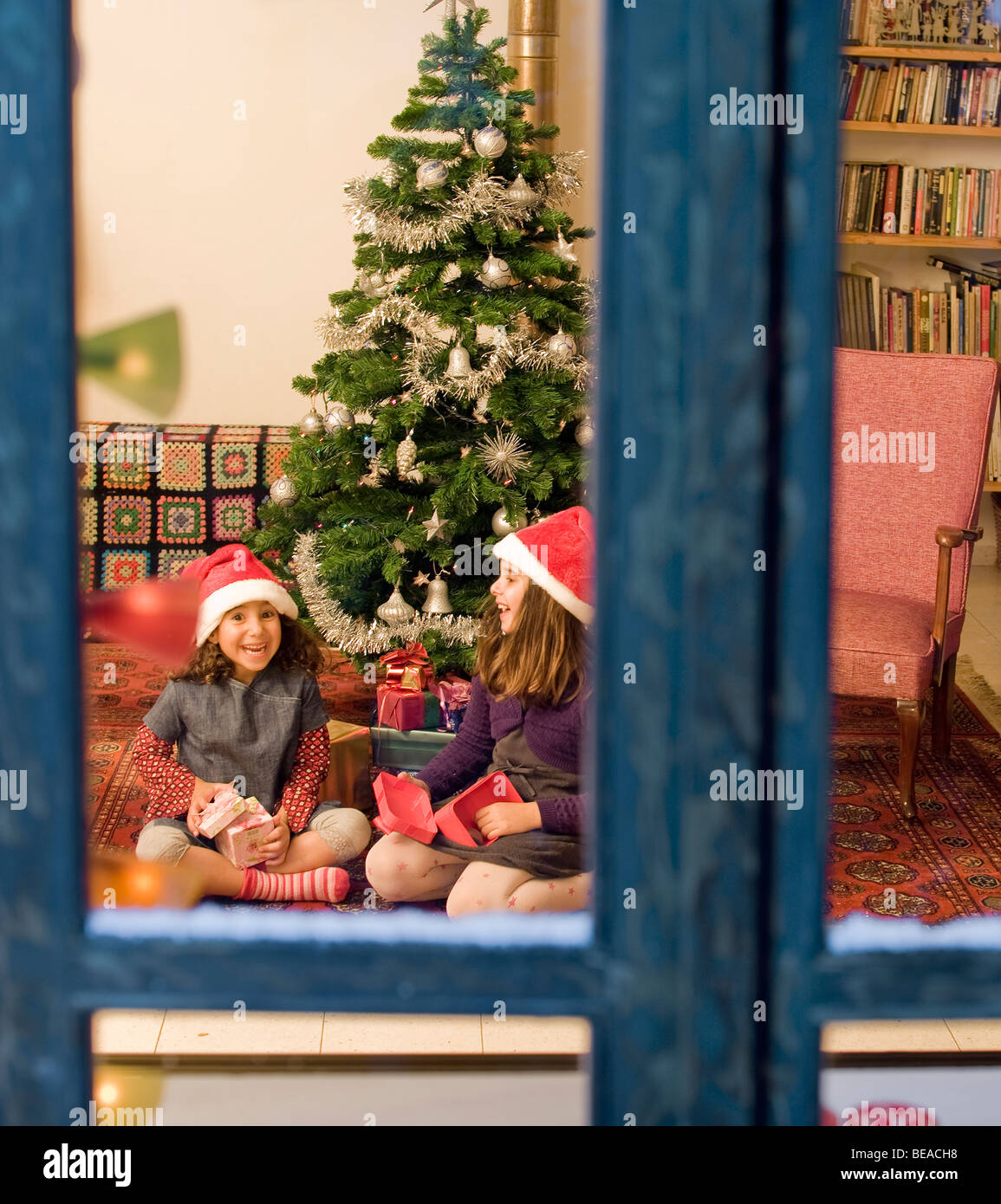 Two sisters open presents on Christmas Stock Photo - Alamy