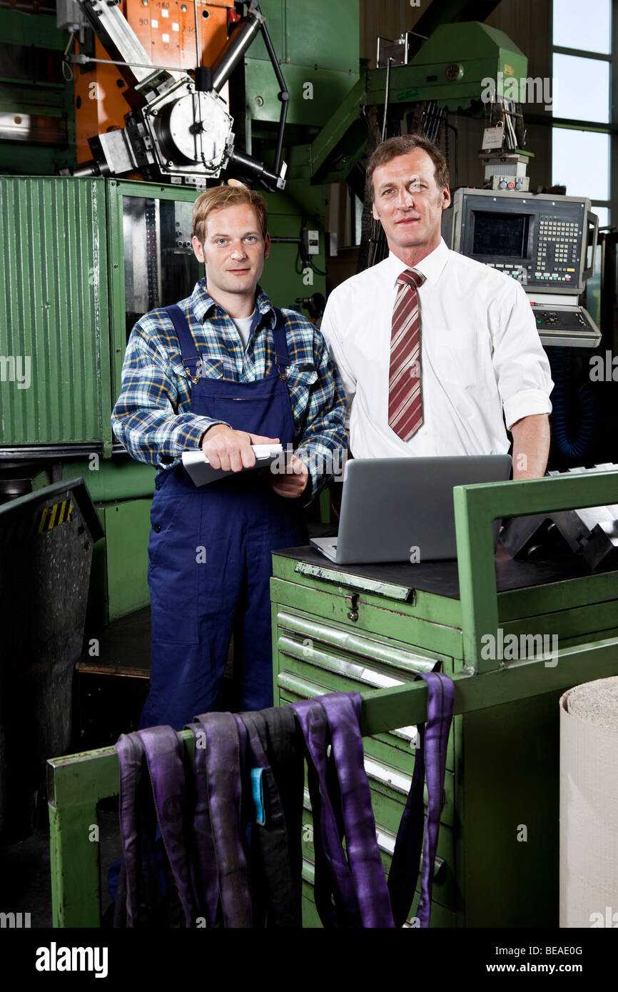 A factory manager and a factory worker in a metal parts factory Stock ...