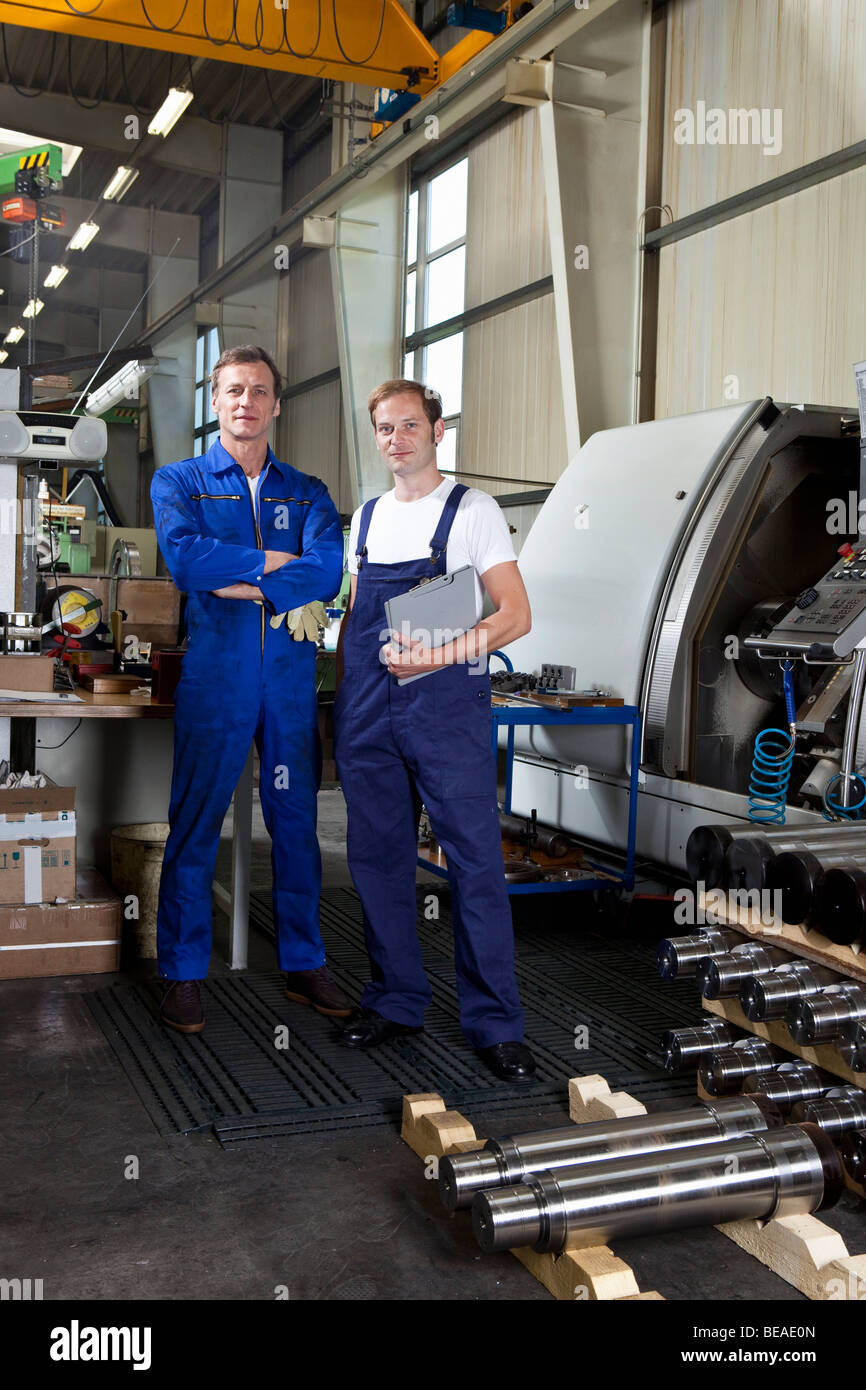 Portrait of two manual workers in a metal parts factory Stock Photo - Alamy