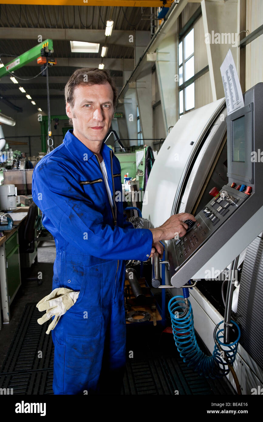 A man operating a machine in a factory Stock Photo - Alamy