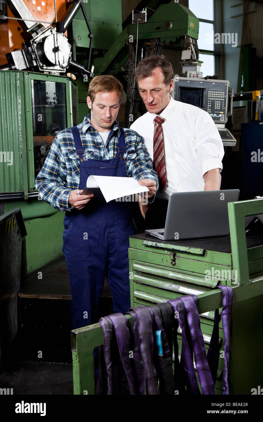 A factory manager and a factory worker in a metal parts factory Stock ...